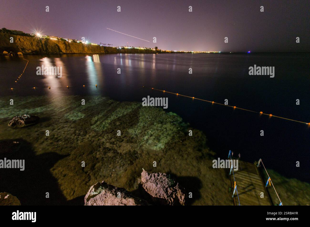Serene beach resort at night features calm waters and soft ambient ...