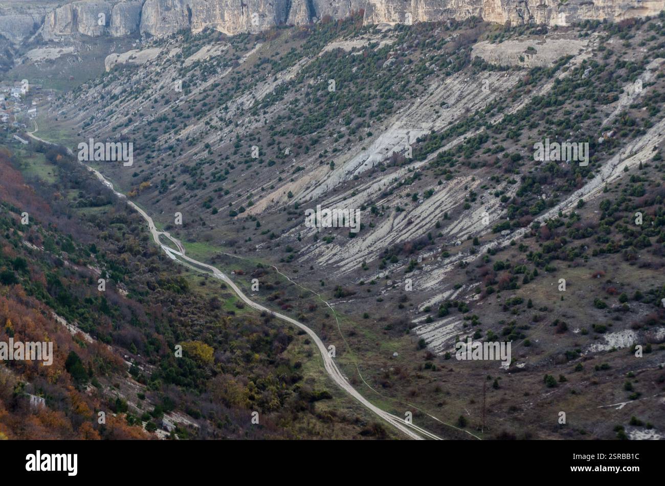 Curving road winds through steep-sided valley in Crimea. Sparse ...