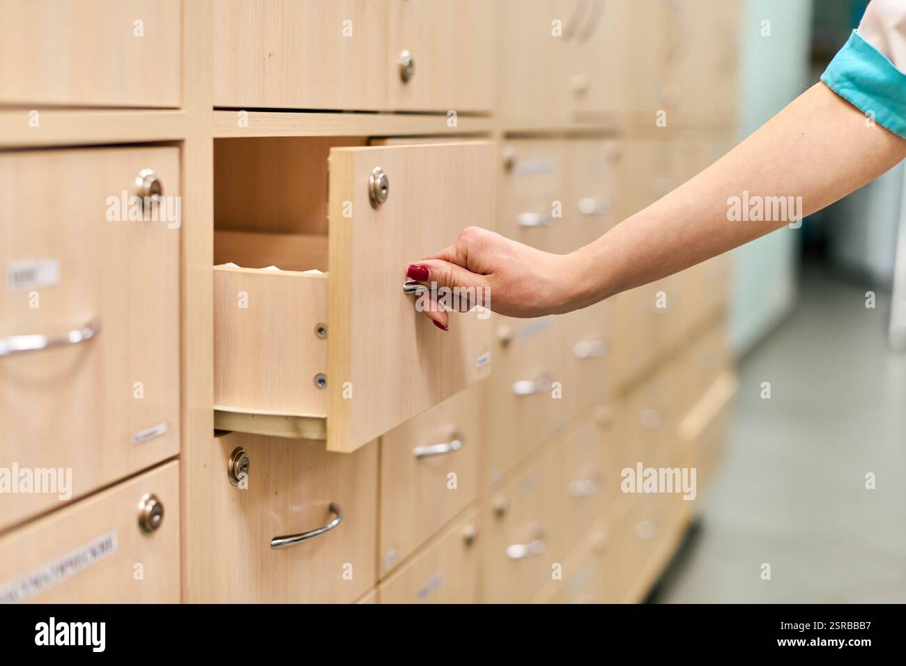 Young adult woman with red nails opens wooden drawer in pharmacy. Soft ...