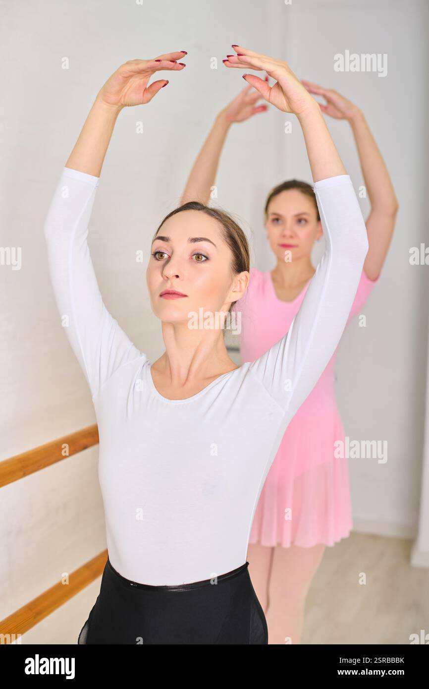 Two young, white, adult female ballerinas in ballet attire practice at ...
