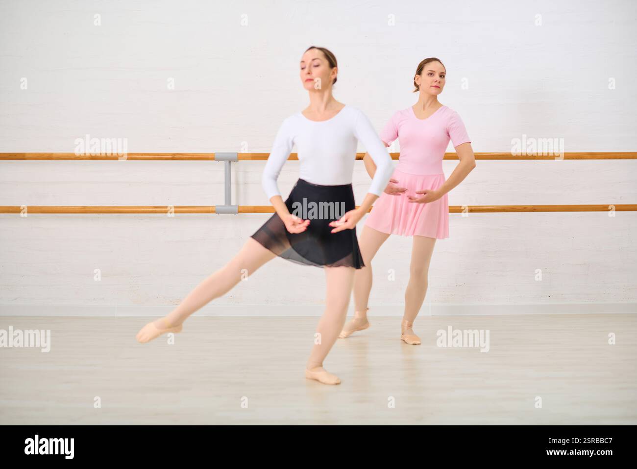 Two young female ballerinas with light hair, in graceful poses at ...