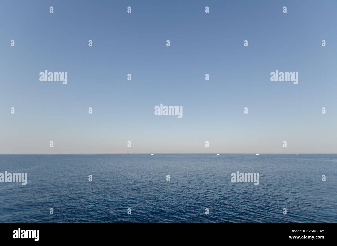 Vast ocean view meets light blue sky at serene resort. Calm waters ...