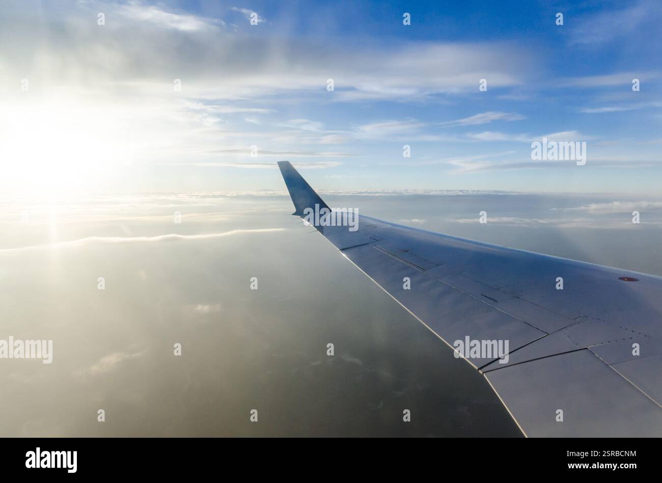 Airplane wing in foreground with soft evening light casting hues of ...