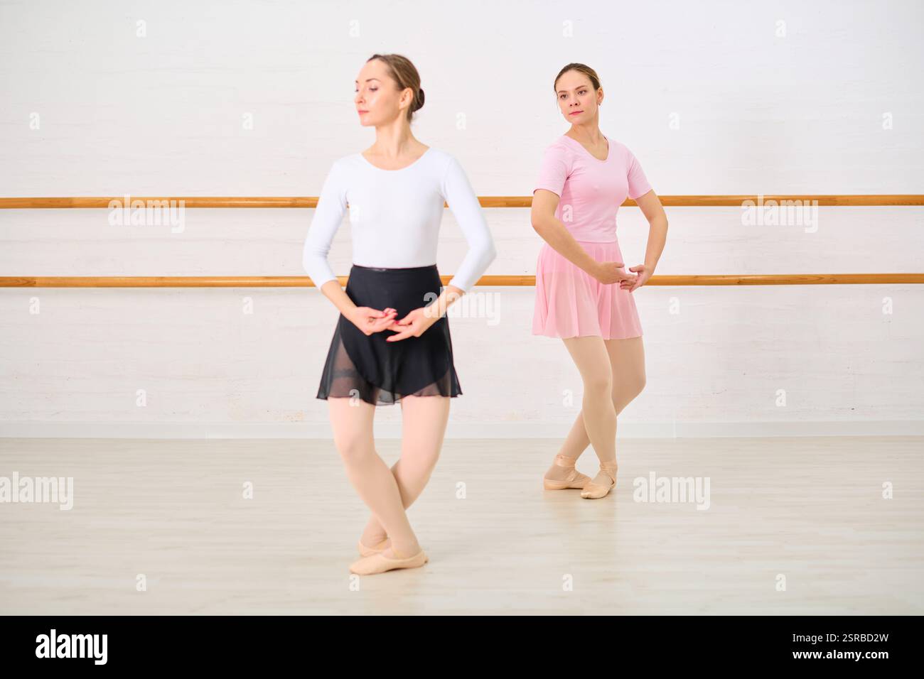 Two young female ballerinas with light hair, in graceful poses at ...