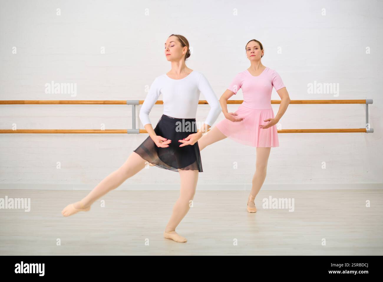 Two young female ballerinas with light hair, in graceful poses at ...
