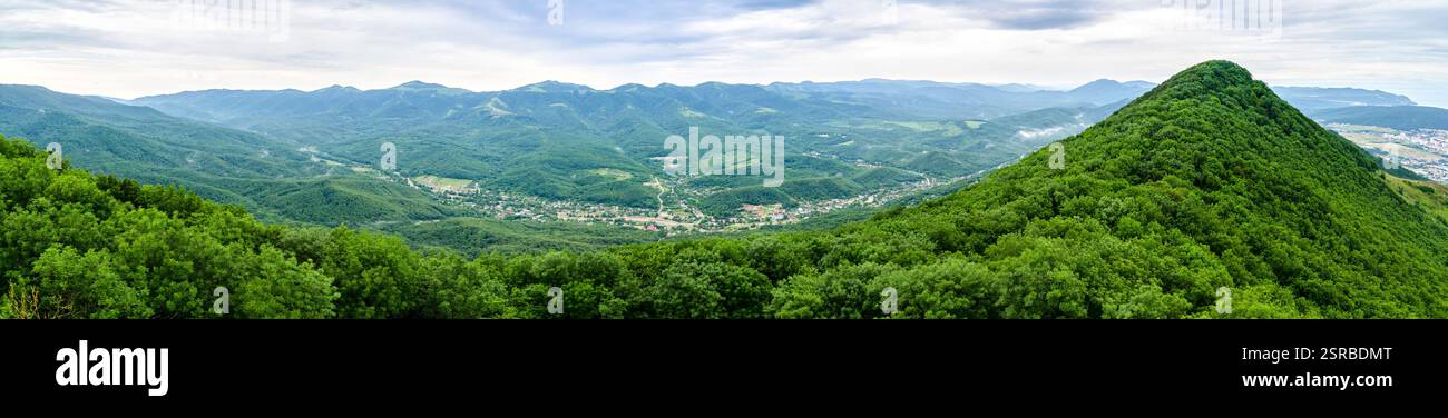 Lush green hills stretch beneath cloudy sky in panoramic view ...