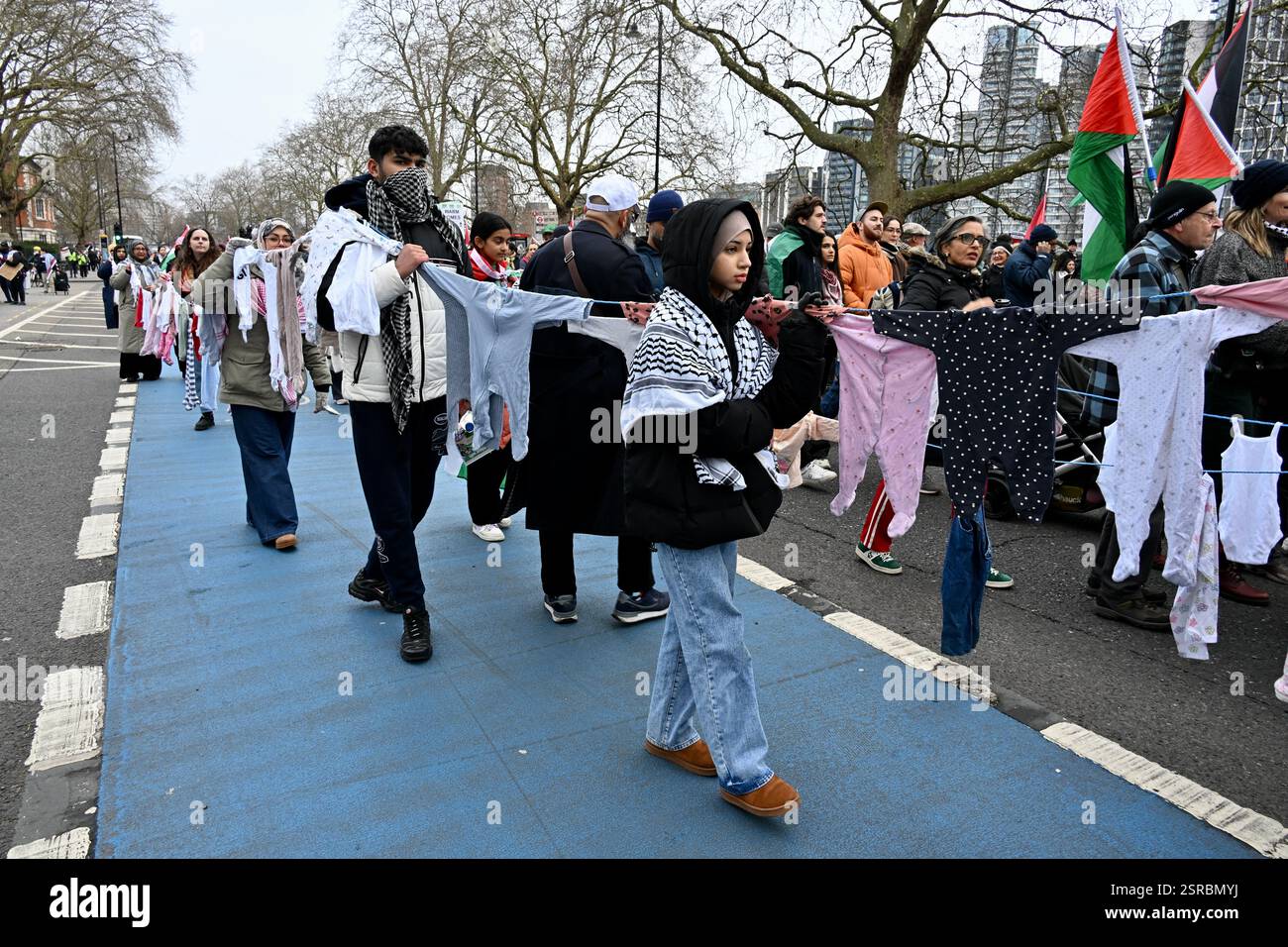 London, UK. Baby clothes hanging on strings symbolise children killed ...