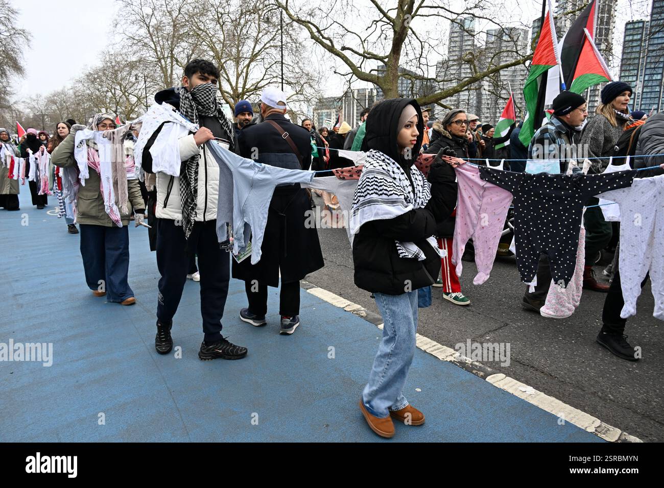 London, UK. Baby clothes hanging on strings symbolise children killed ...