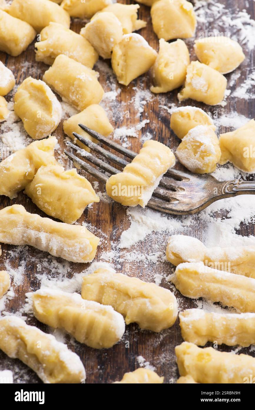 Uncooked homemade potato gnocchi with fork Stock Photo - Alamy