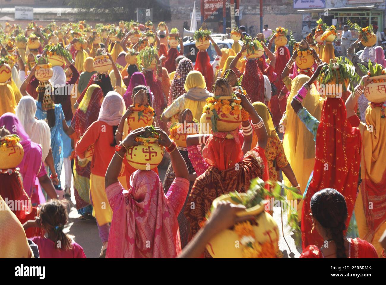 Rajasthani ladies in colourful sari and yellow pitcher on head ...