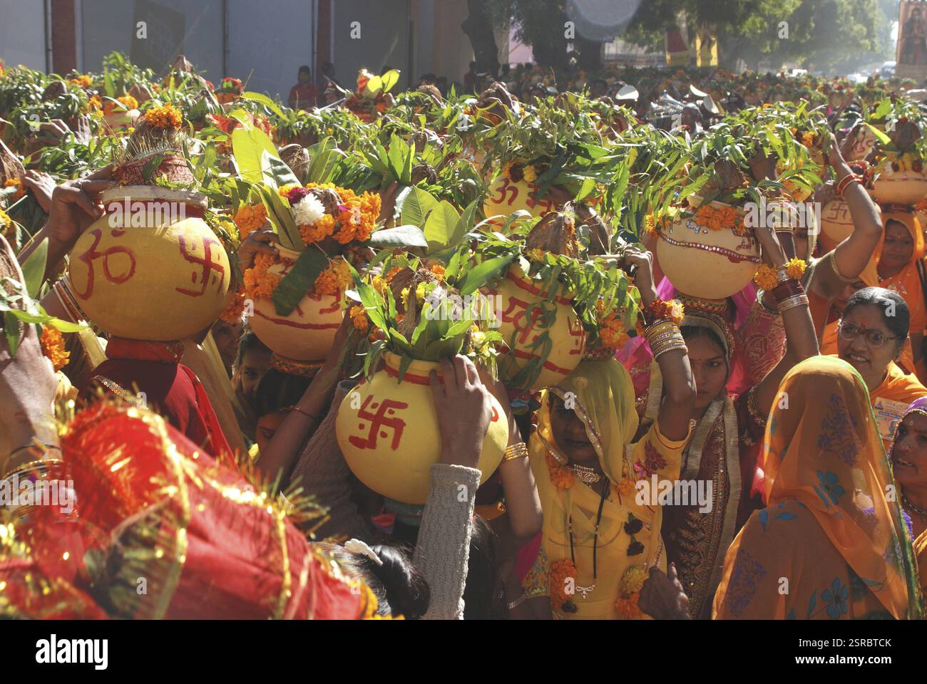 Rajasthani ladies in colourful sari and yellow pitcher on head ...