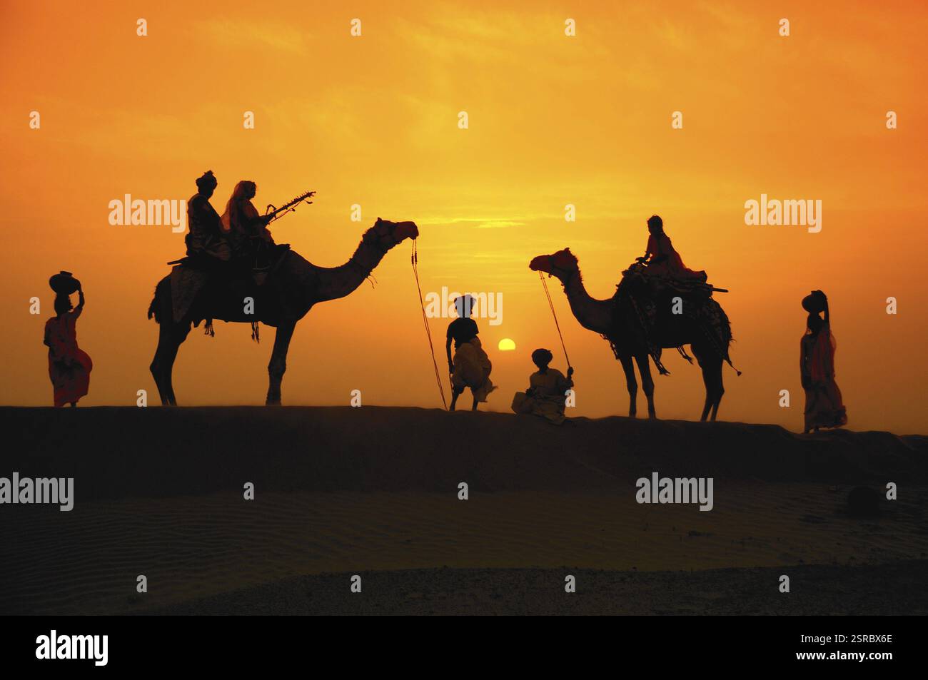 People riding camel at sunset in Thar desert, Jaisalmer, Rajasthan ...