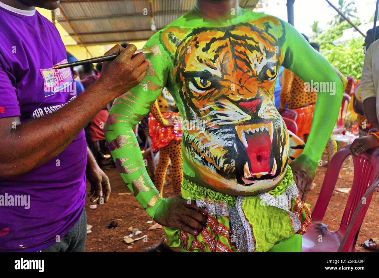 Artists painting bodies for Pulikali Tiger Dance, Onam festival, Kerala ...