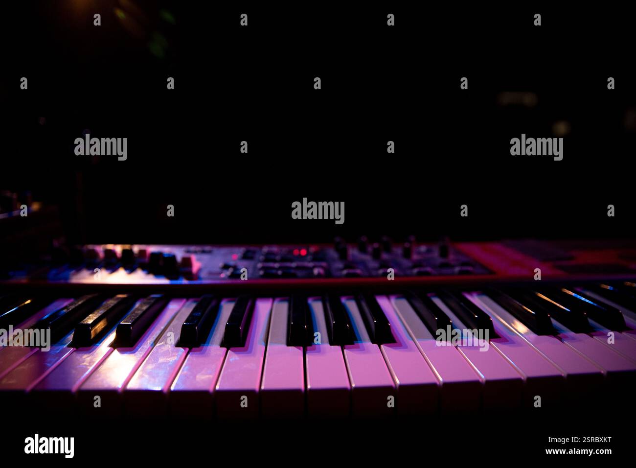 An exquisite closeup view of piano keys illuminated by soft, dim ...