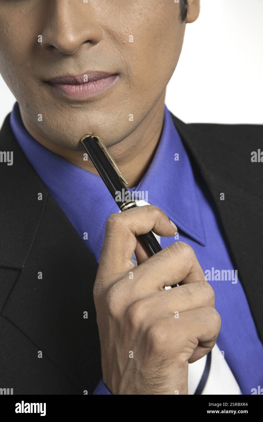 Executive holding pen touching to corner of lip MR#687M Stock Photo - Alamy