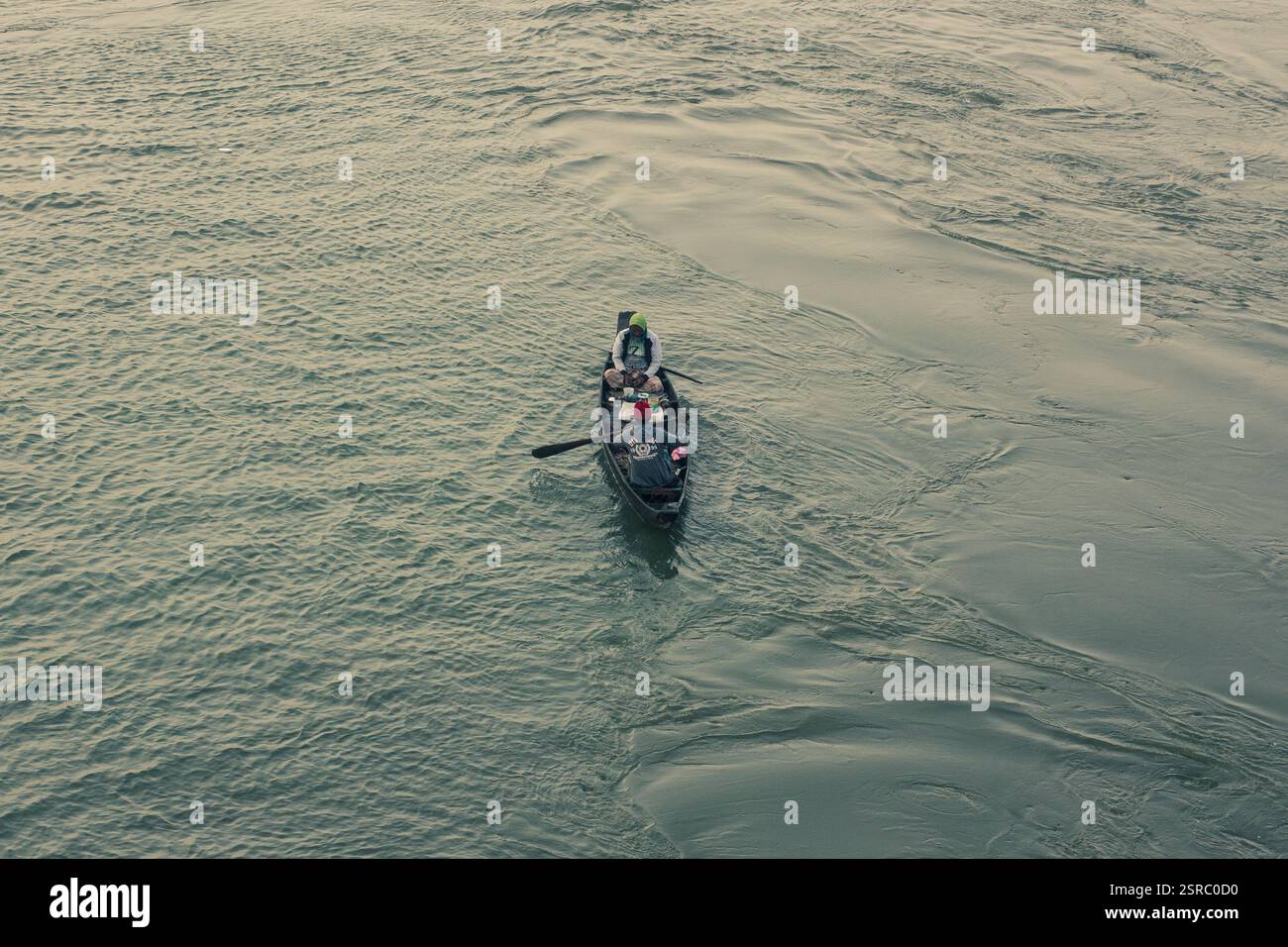 A traditional wooden boat carrying people and goods on a calm river ...