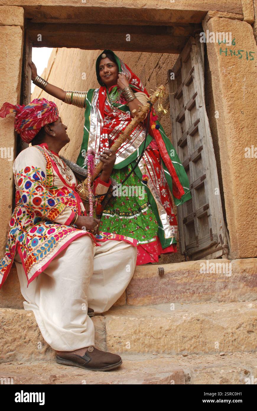 Rajasthani folk musician playing ravanhatta and lady listening ...