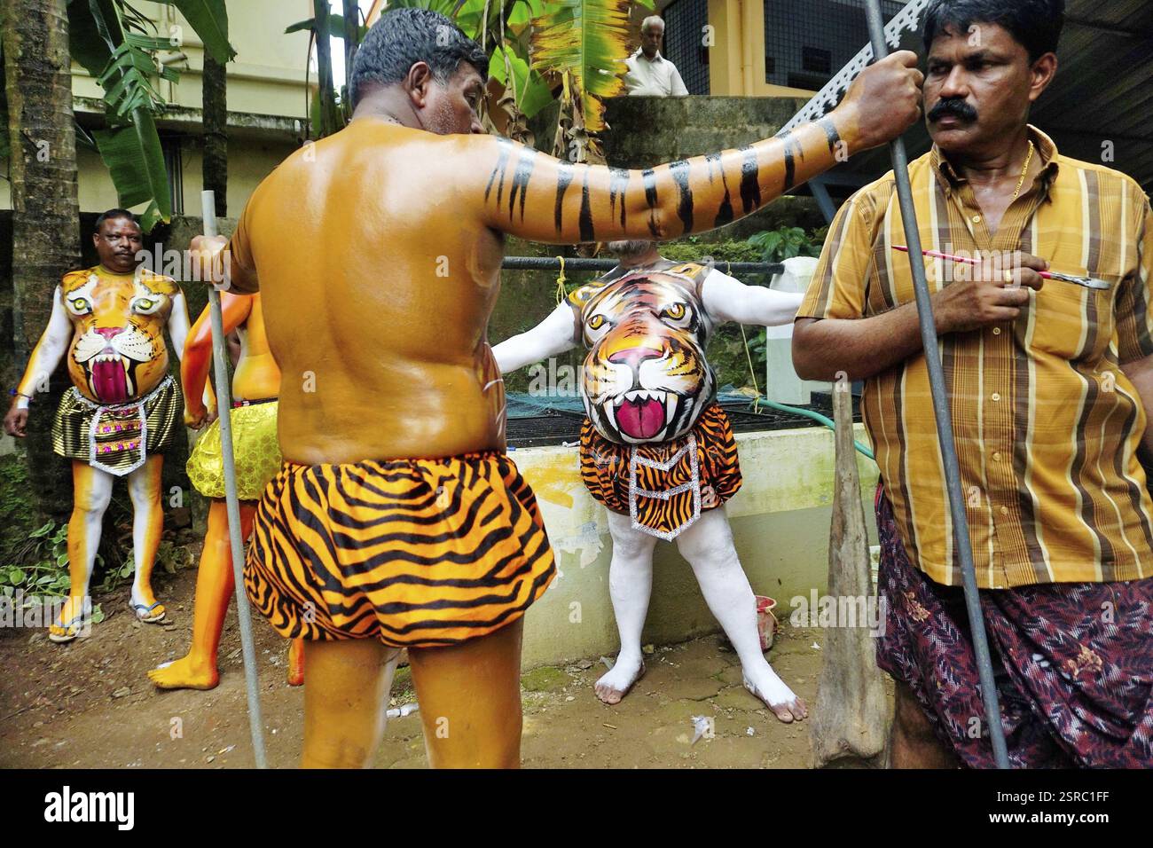 Artists painting bodies for Pulikali Tiger Dance, Onam festival ...