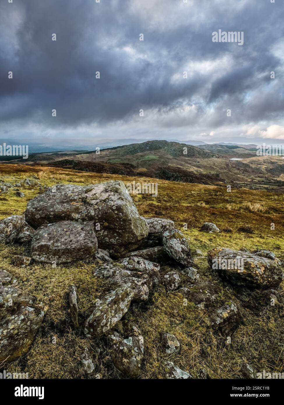 A landscape with scattered boulders on the hillside and rolling green ...
