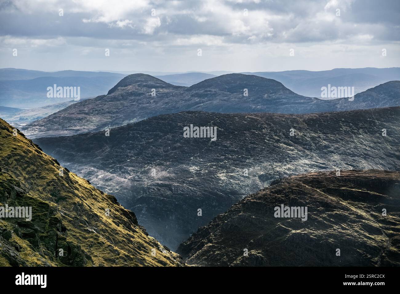 A dramatic view of rolling mountains features rocky slopes and subtle ...
