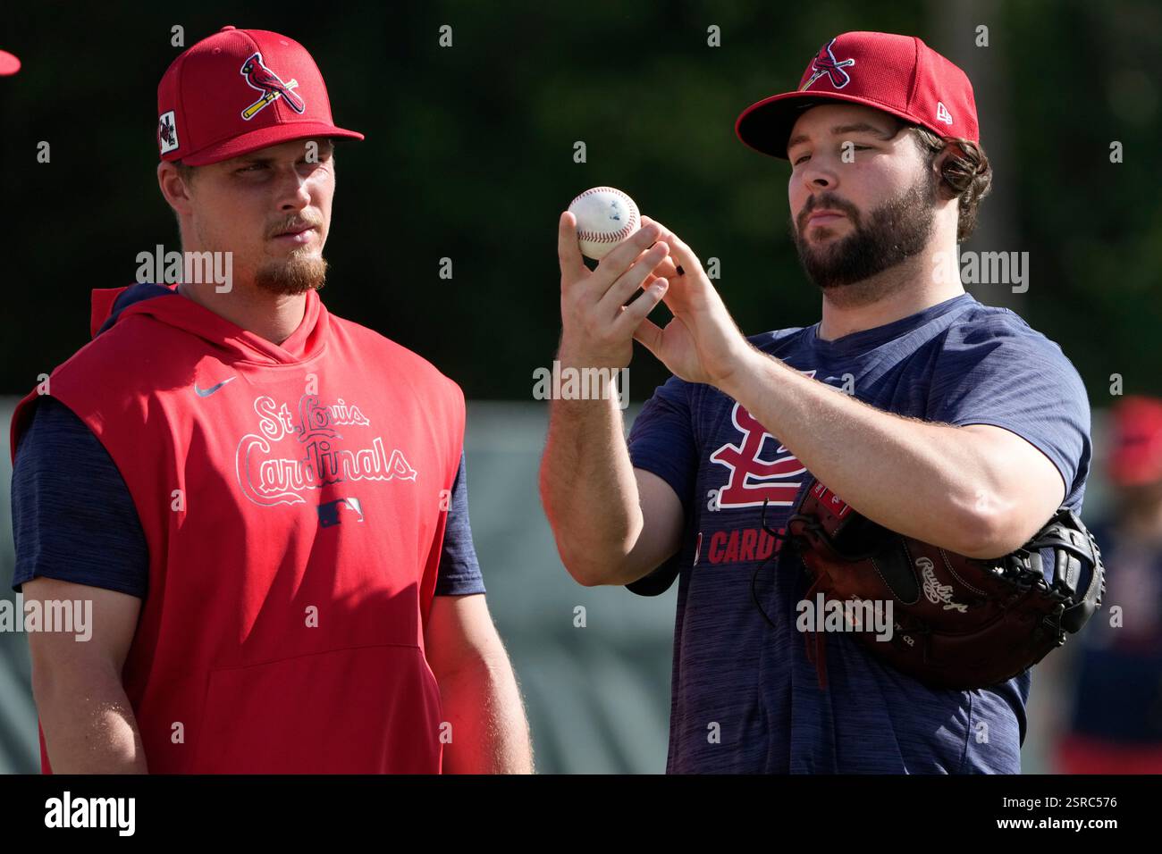 St. Louis Cardinals' Alec Burleson, right, examines a ball as teammate ...