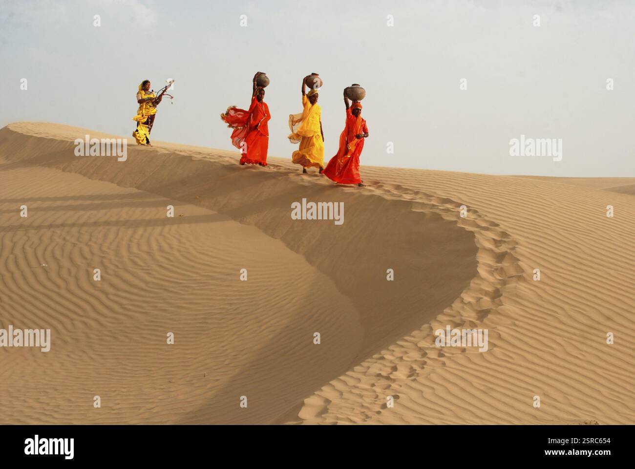 Rajasthani women with pitchers on head and one playing ravanhatta ...