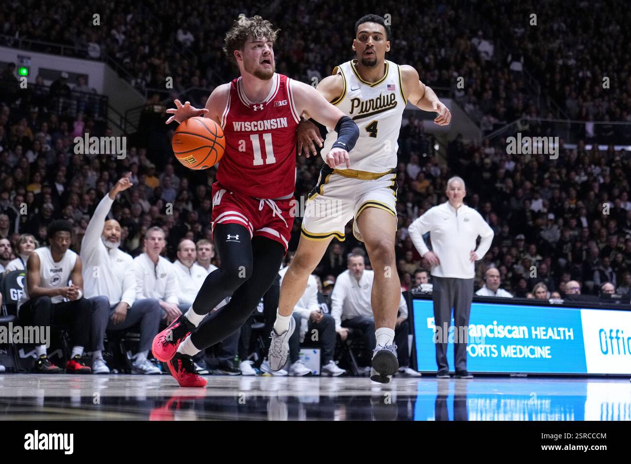 Wisconsin guard Max Klesmit (11) drives past Purdue forward Trey ...