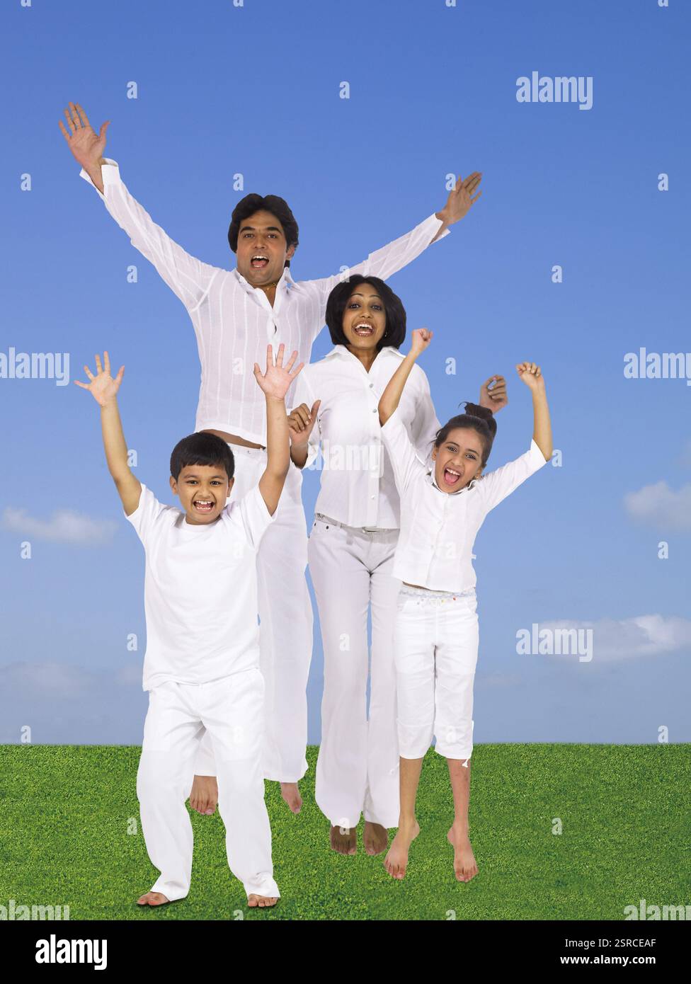 Parents and children in white costumes jumping with joy MR Stock Photo ...
