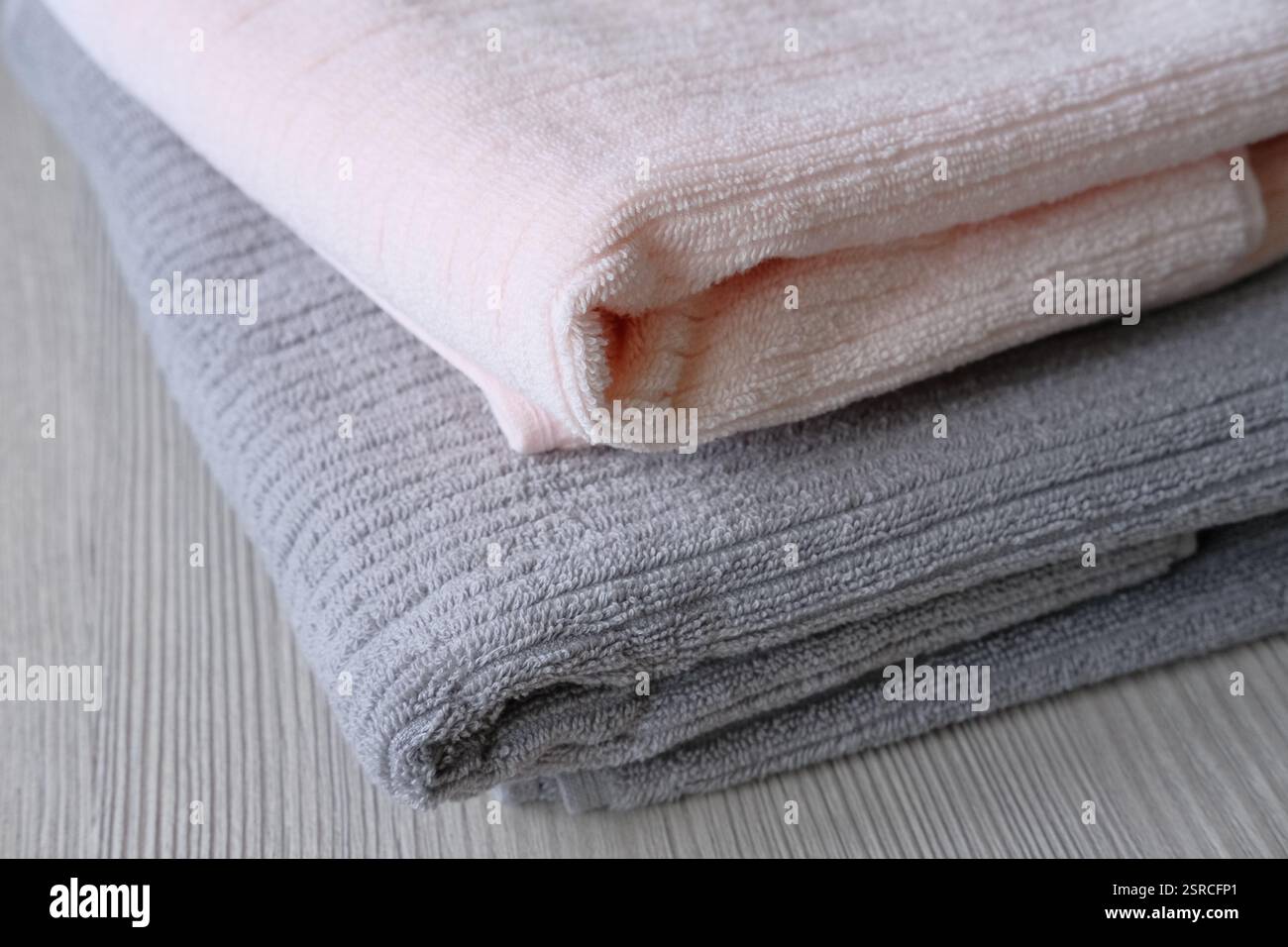 Pink and grey bath towels on the table. Hygiene, fabric,spa and textile ...