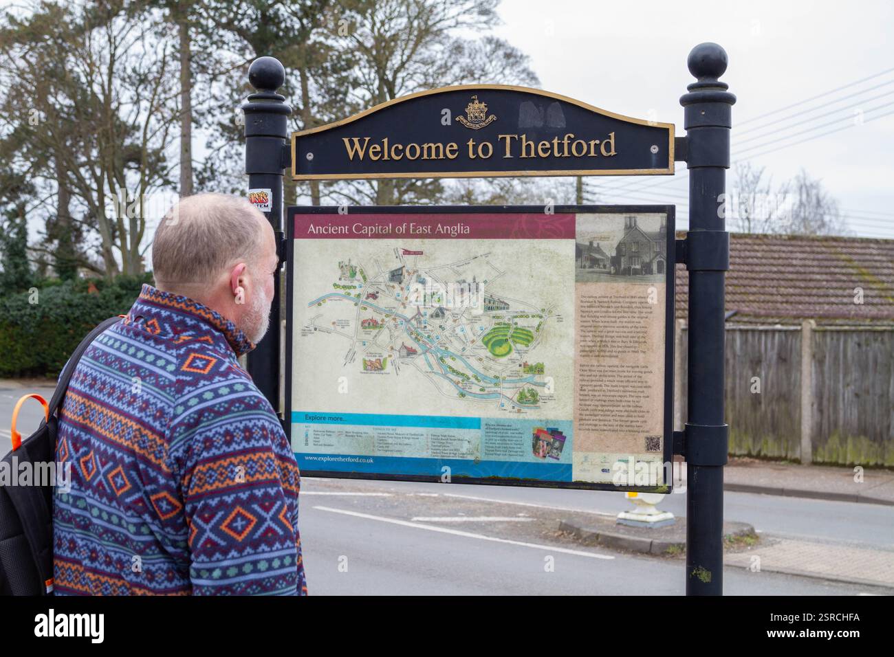 A middle aged man reading a tourist sign outside Thetford station. It ...