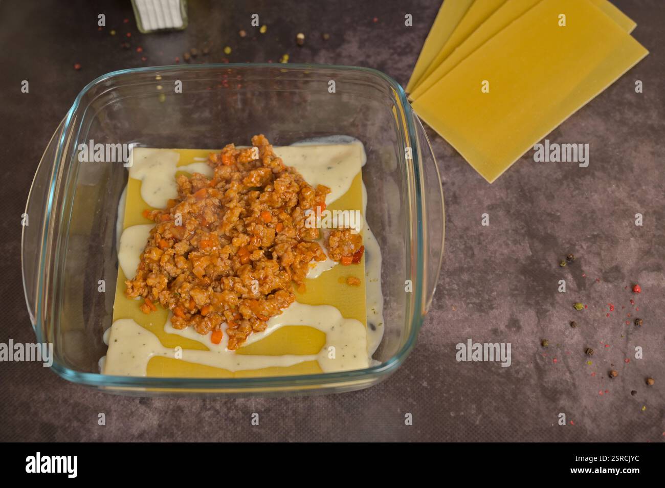 Bolognese and béchamel sauces in a glass form. Lasagne pasta sheets ...