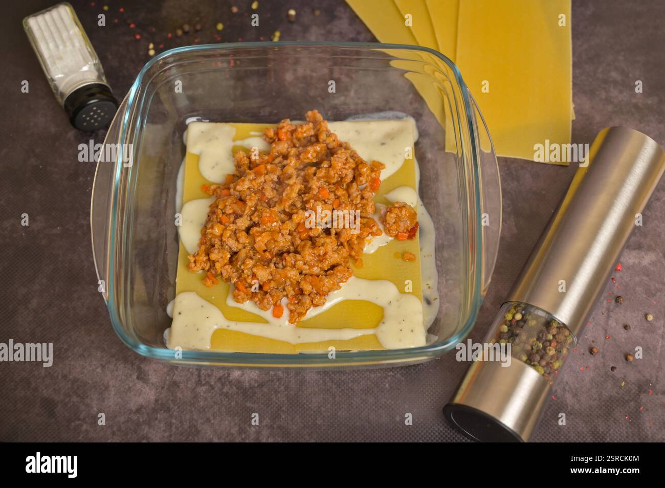 Bolognese and béchamel sauces in a glass form. Lasagne pasta sheets ...