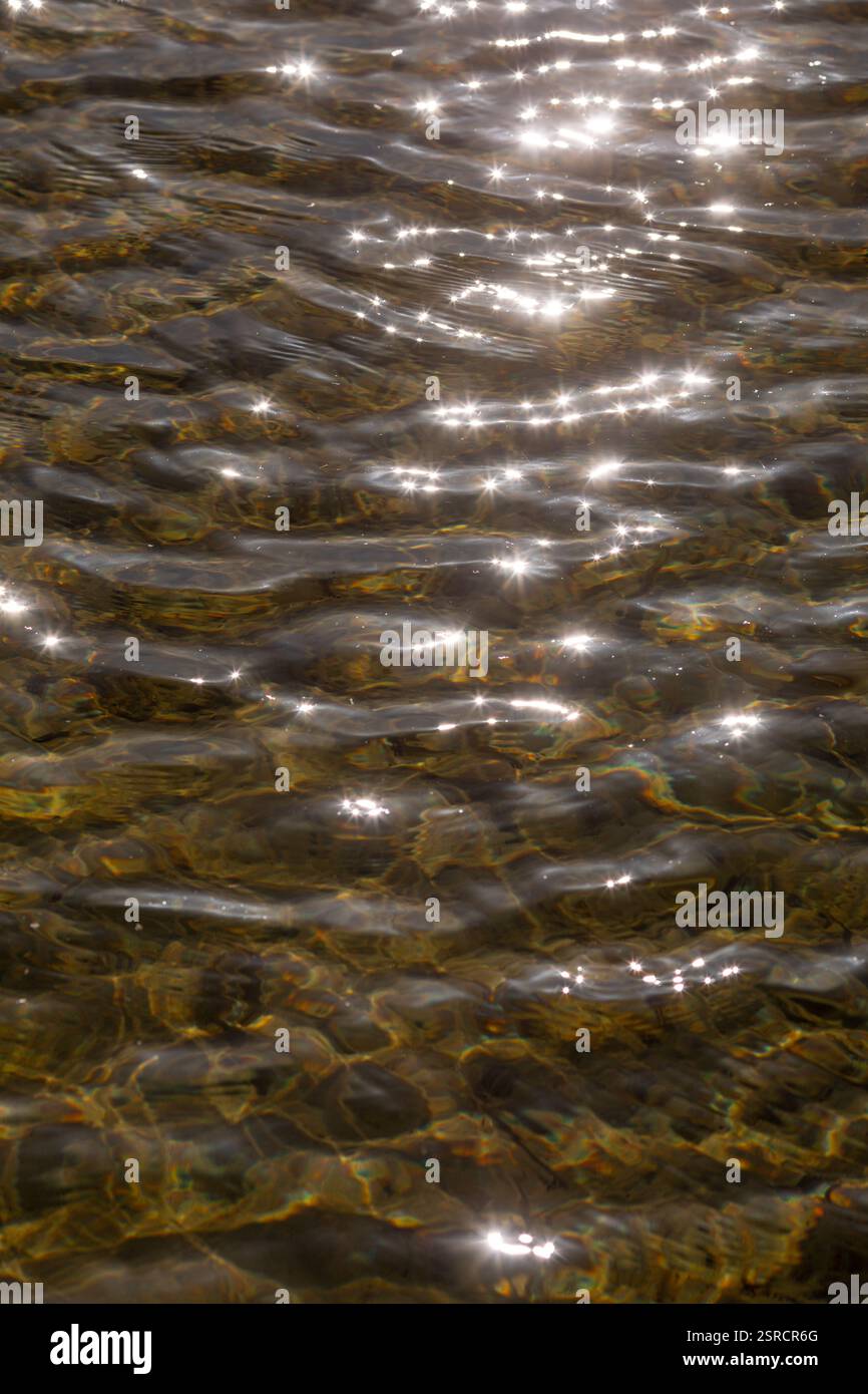The beautiful glistening water ripples gently under the warm and bright ...