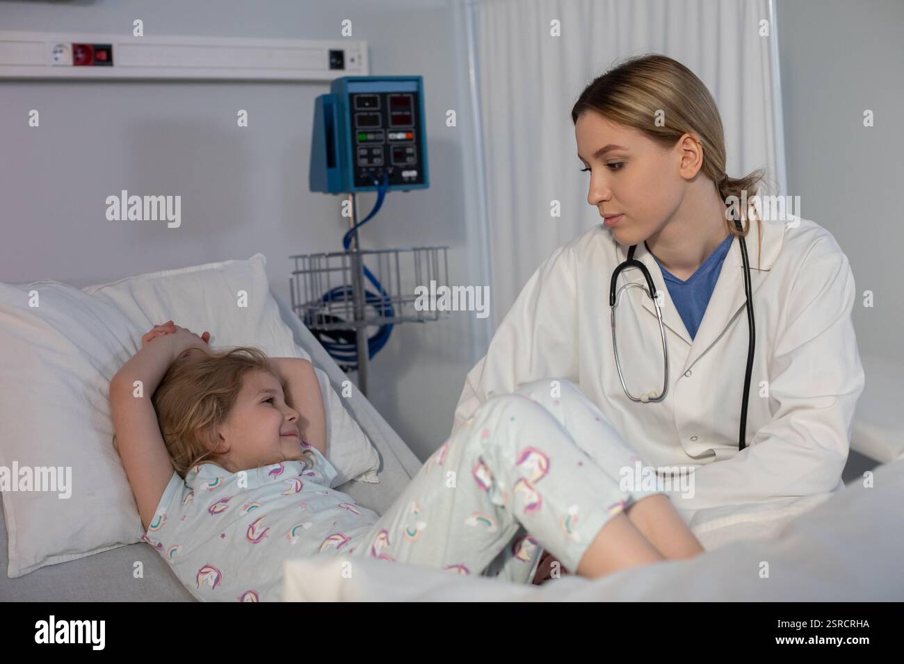 A compassionate doctor is providing comfort to a child in a hospital ...