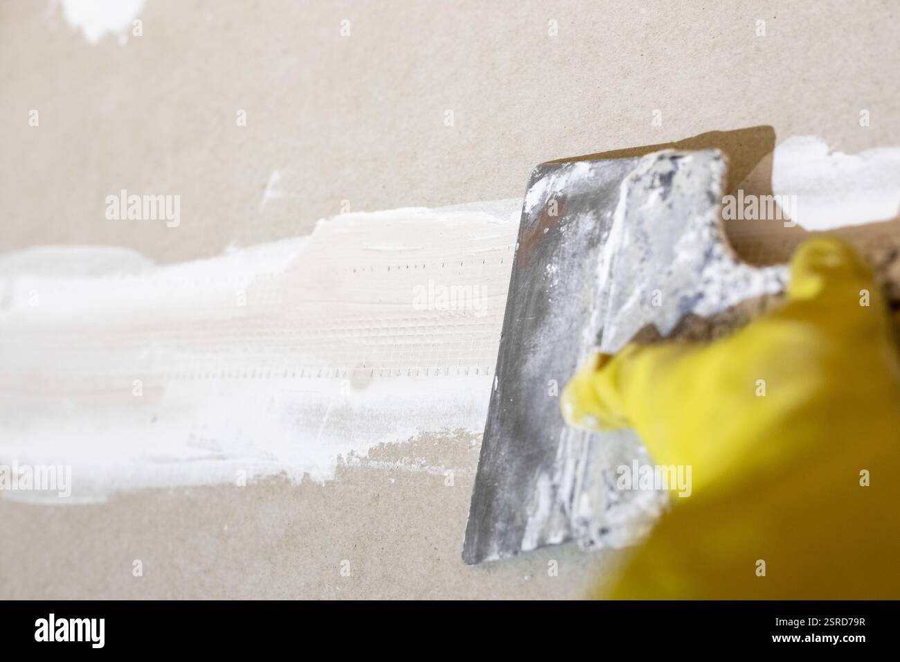 Preparing drywall for plastering. The craftsman cleans and sands the putty from the joints and ...