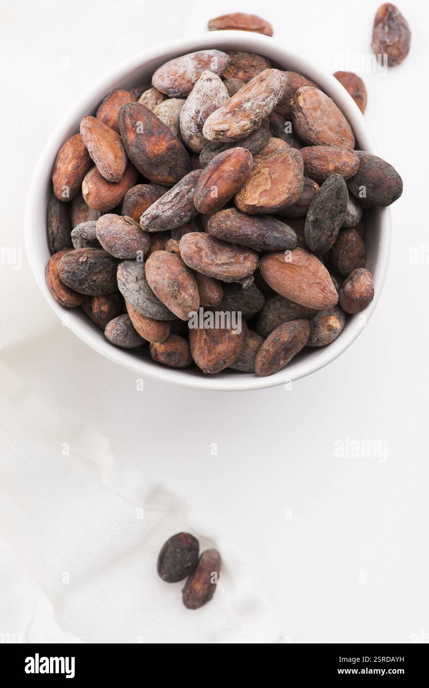 Bowl of cacao beans on a white background Stock Photo - Alamy