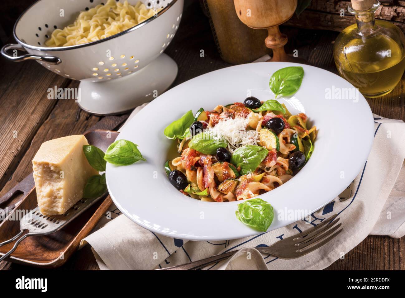 Ribbon Pasta with courgette and olives in tomato sauce Stock Photo - Alamy