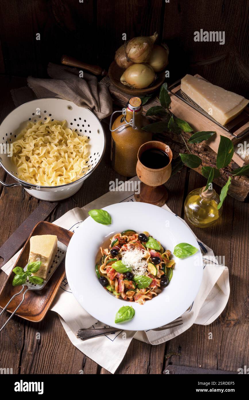 Ribbon Pasta with courgette and olives in tomato sauce Stock Photo - Alamy
