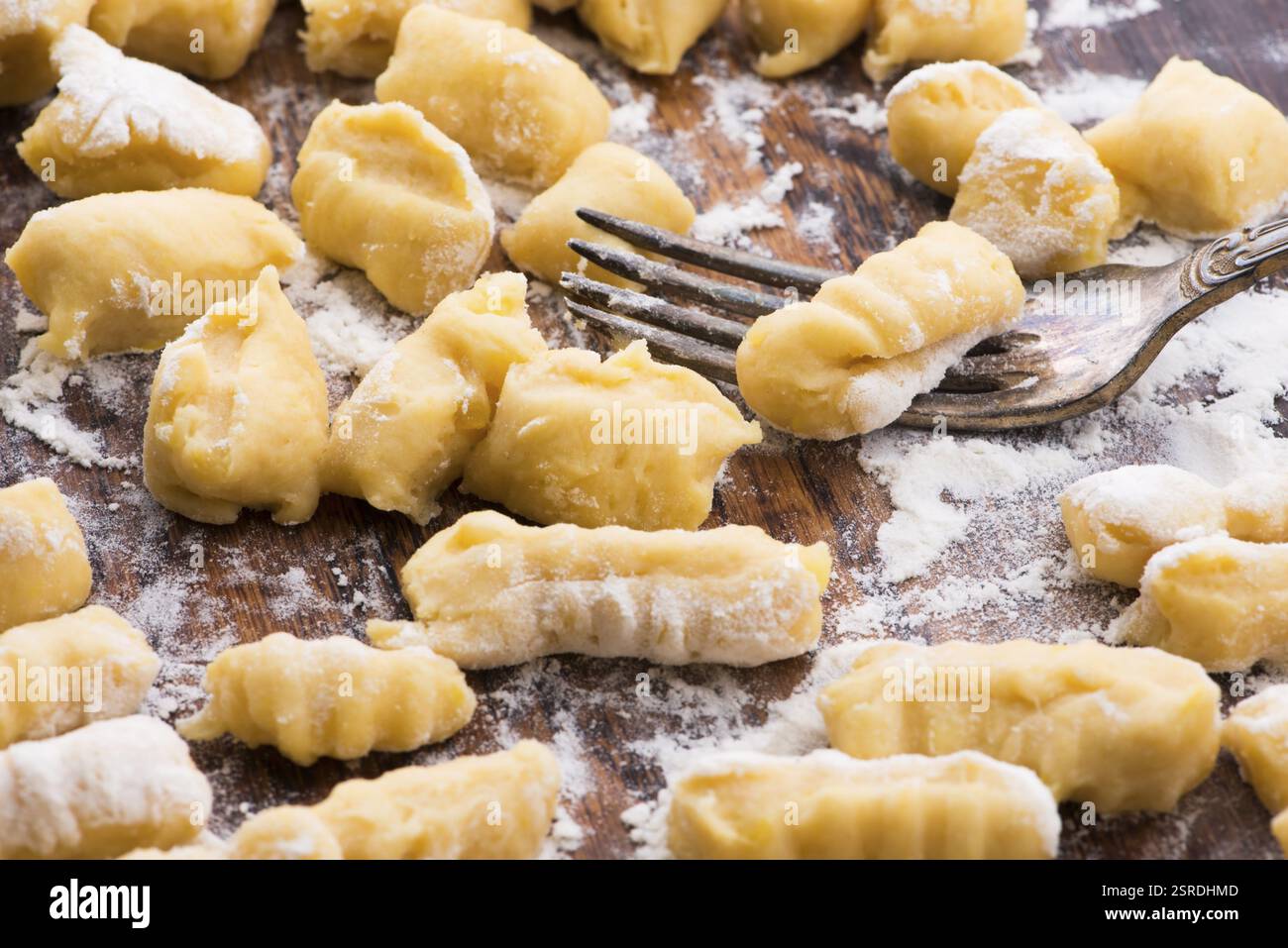 Uncooked homemade potato gnocchi with fork Stock Photo - Alamy