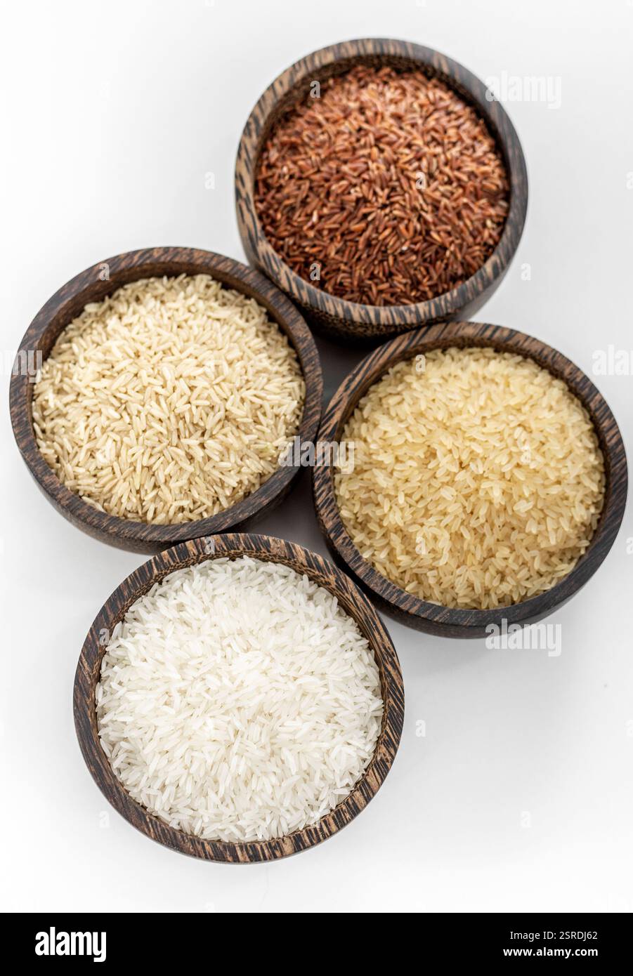 different kinds of asian rice grains in bowls on white background in ...