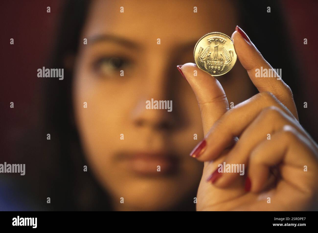 Lady looking at Indian one rupee coin MR#201 Stock Photo - Alamy