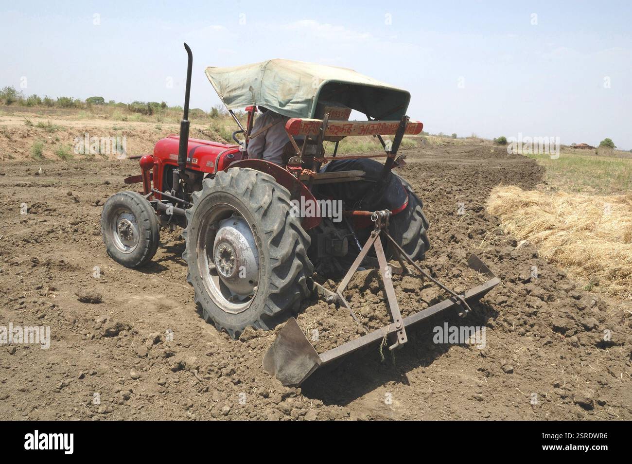 Farmer with tractor in field, Singhpur, Narsinghpur, Madhya Pradesh ...