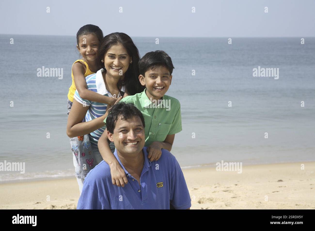 South Asian Indian parent and children standing behind each other on ...