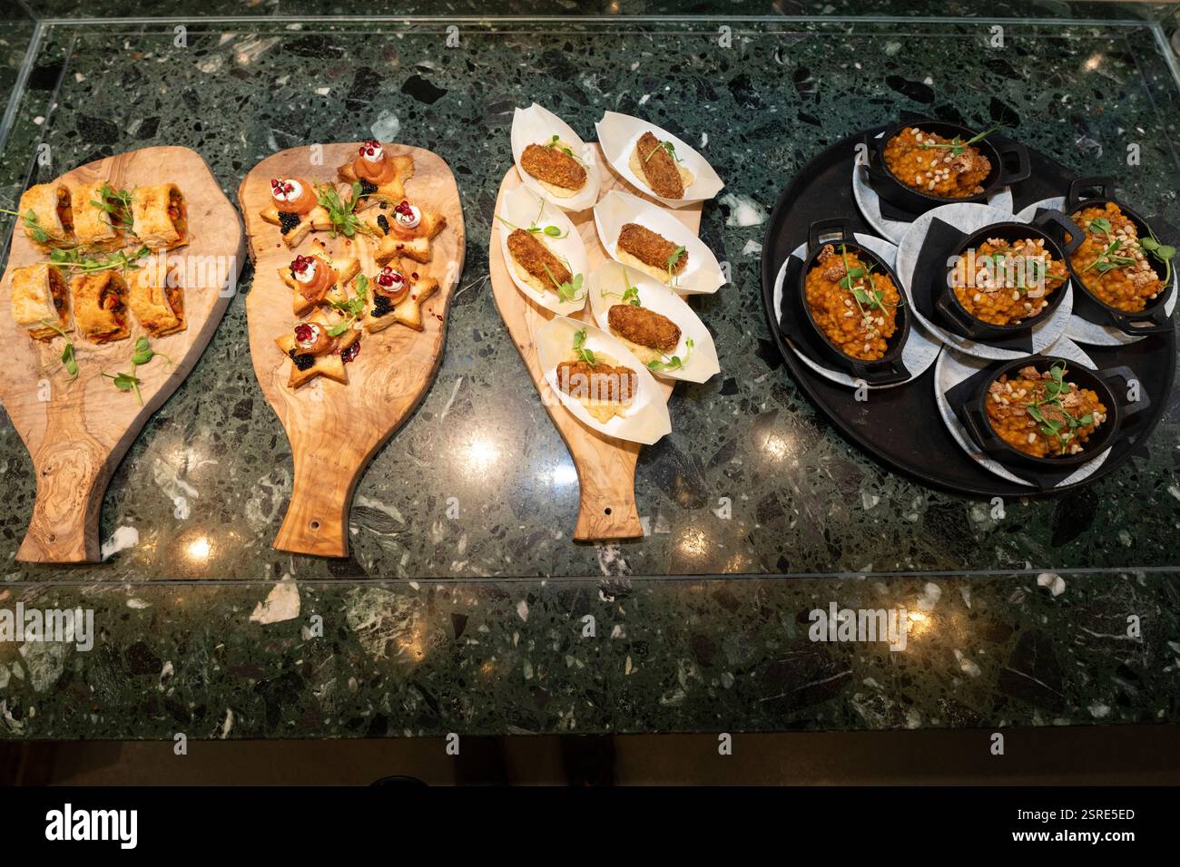 Various appetizers (pastries, tapas, risotto) displayed on wooden ...