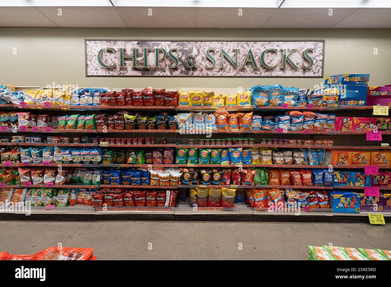 Grocery store chips & snacks aisle. Various brands, flavors, and sizes ...