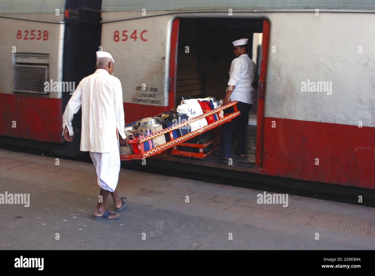 Dabbawala pulling lunchboxes crate in train, Bombay Mumbai, Maharashtra ...