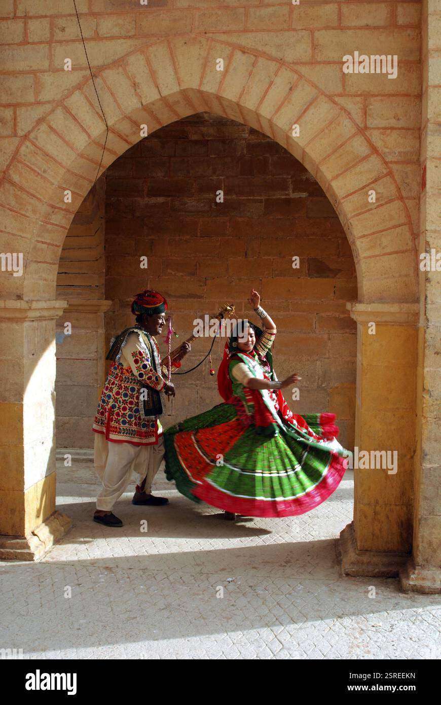 Folk dancer dancing with musician in porch of Gadisar Gadsisar lake ...