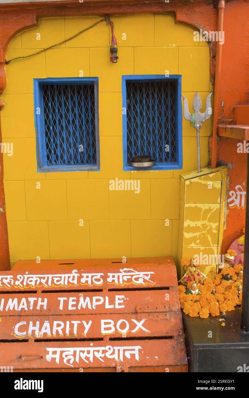 Orange charity box of ancient Ganga temple with blue windows and ...