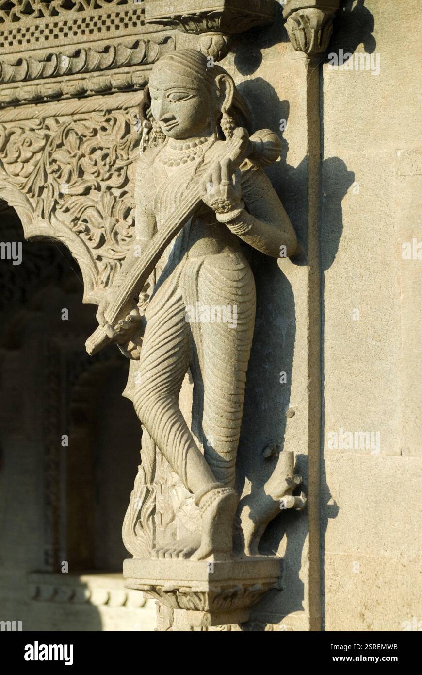 Woman playing veena music instrument carved in stone on the wall at ...