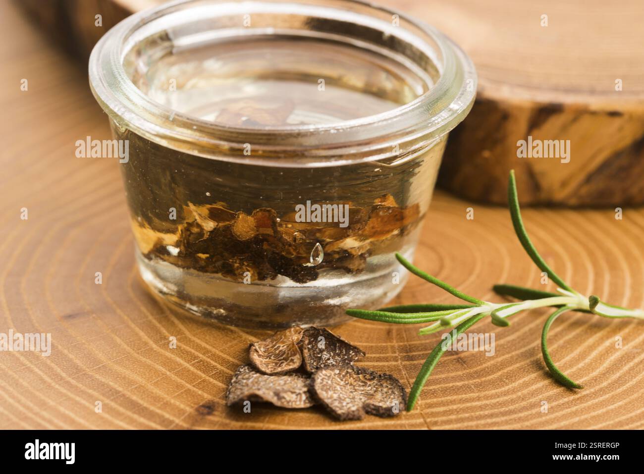 Sliced black truffle in olive oil in small jar and fresh rosemary Stock ...